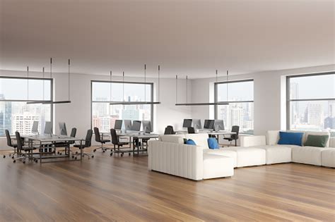 현대적인 사무실 방 인테리어 테이블에 데스크톱 컴퓨터 흰색 벽 나무 바닥 파노라마 도시 전망 창 파란색 베개가있는 새로운 빈 소파 국제 협력의 개념 3d 렌더링 3차원