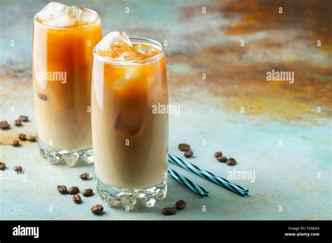 Ice Coffee In A Tall Glass With Cream Poured Over And Coffee Beans Cold Summer Drink On A Blue