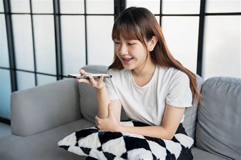 친구와 이야기하는 스마트폰을 입 가까이 들고 있는 아시아 여성 20 24세에 대한 스톡 사진 및 기타 이미지 20 24세 Brand Name Smart Phone