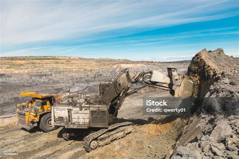 석탄 광산의 흰색 큰 굴 삭 기는 배경에 밝은 태양과 멋진 푸른 하늘과 함께 품종을 로드 합니다 광업 트럭 광산 기계 탄광 기술 고고학에 대한 스톡 사진 및 기타 이미지