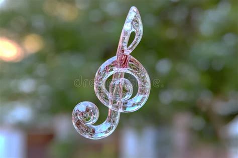 A Single Glass Musical Note Hangs From A String Ready To Be Played