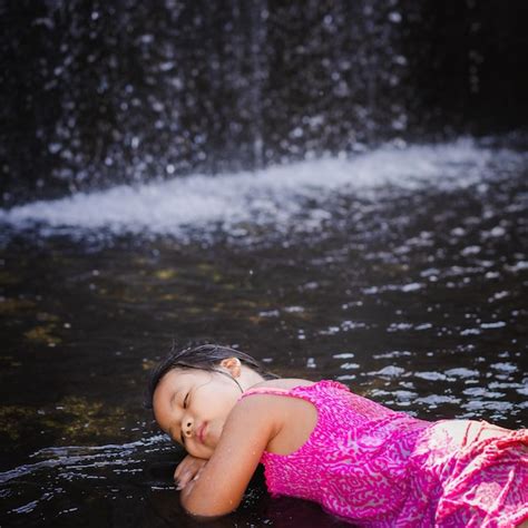 Premium Photo Cute Girl Lying Against Waterfall