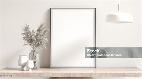 빈 검은색 포스터 프레임 모형입니다 나무 캐비닛 가구에 유리 화병 조각품 및 램프에 말린 꽃을 놓습니다 하얀 방 배경 크림색 창문에서 들어오는 자연광 3d 렌더링 0명에