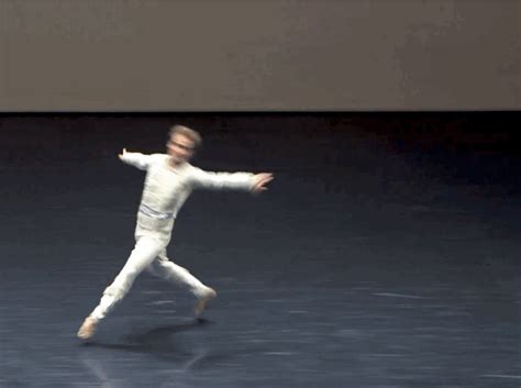 A Man In White Is Dancing On The Floor With His Arms Out And Legs