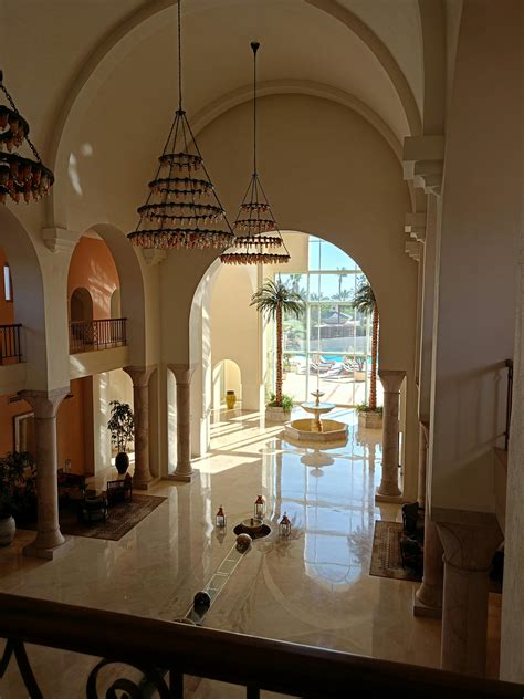건축 관광 기둥 널찍한 대리석 바닥 럭셔리 로비 리조트 목적지 반사 밝기 상류층의 샹들리에 수영장 전망 실내 아치 길 아치형 천장 야자나무