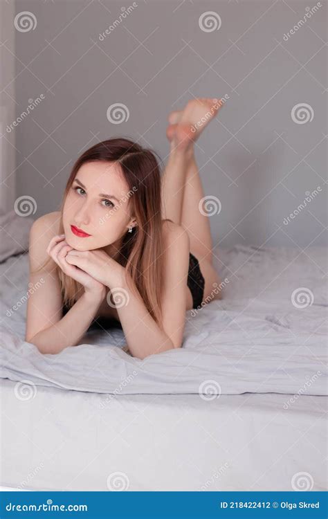 Redhead Model In Black Lingerie Is Lying On Bed With Grey Sheets Stock Photo Image Of Grey
