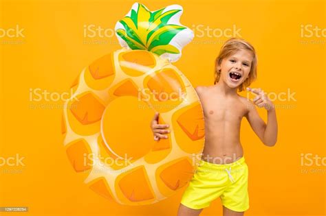 수영 트렁크에서 잘 생긴 소년은 고무 반지를 보유하고 미소와 오렌지 배경에 고립 된 몸짓 공 스포츠 장비에 대한 스톡 사진 및 기타 이미지 공 스포츠 장비 바다