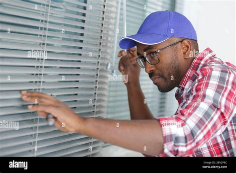 A Man Adjusting Window Blind Stock Photo Alamy