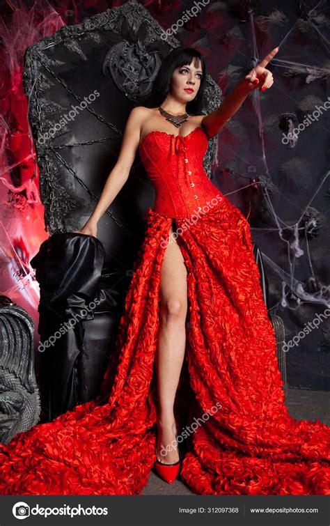 Beautiful Vampire Woman In Red Long Dress Near Big Black Throne In The Studio Stock Photo By