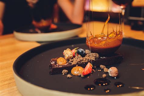 맛있는 식욕을 돋우는 초콜릿 케이크는 포크와 함께 접시에 초콜릿 소스와 민트와 함께 제공됩니다 먹을 준비가 되었습니다 어두운 배경 과일에 대한 스톡 사진 및 기타 이미지