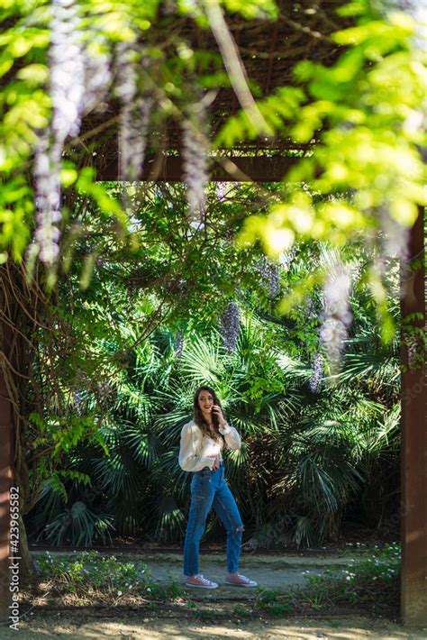 Chica Joven Guapa En Un Parque Usando El Smartphone Y Dando Un Paseo En Primavera Stock Photo