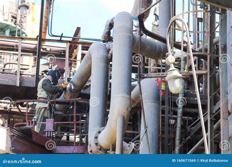 Worker Repairman Fitter Welder Repairs A Pipeline At A Refinery