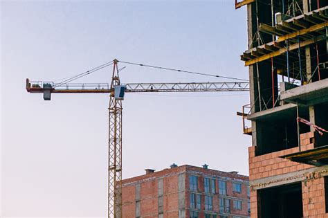 하늘 배경 크레인과 건물 건설 사이트입니다 크레인과 햇빛에 건물 벽돌의 실루엣 산업 풍경입니다 텍스트를 위한 공간입니다 강철 및 콘크리트 개발 강철에 대한 스톡 사진 및