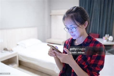 Young Girl Looking At Mobile Phone In Hotel Room ストックフォト Getty Images