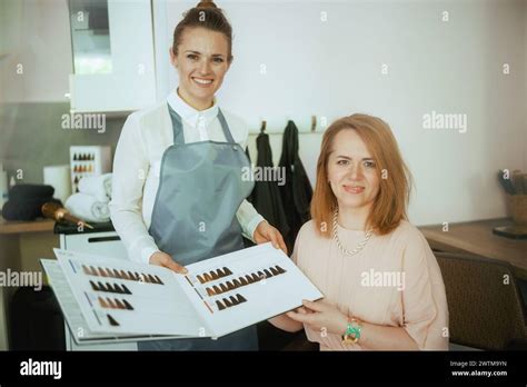 Woman Hair Salon Worker In Modern Hair Studio With Hair Color Chart And
