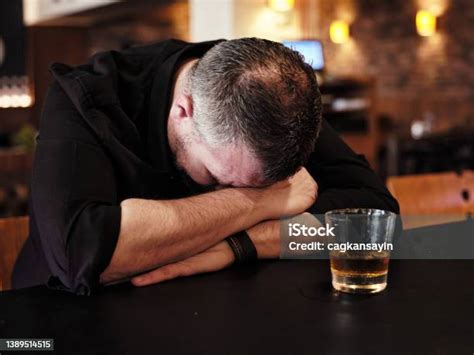 술에 취한 남성 고객은 술집에서 위스키 한 잔과 함께 바 카운터에서 자고 있습니다 알코올 중독 음주 문제 성년 남자에 대한 스톡 사진 및 기타 이미지 Istock