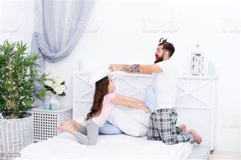 우리는 함께 가족을 만듭니다 행복한 가족 아버지와 딸의 가족은 침실에서 즐거운 시간을 보냅니다 아버지와 어린 아이는 베개 싸움을합니다 가족 게임 2명에 대한 스톡 사진 및