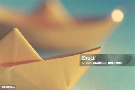 푸른 종이로 만든 바다에서 종이 접기 노란색 항해 보트 푸른 종이 바다에서 비행 선박 바다와 보케 조명 노란색 항해 보트종이