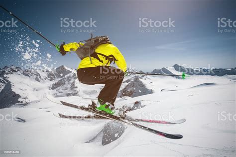 전체에서 스키 스포츠 푸른 하늘 및 백색 인종 눈 덮인 산의 배경에 대 한 빙하의 상단에서 심 연으로 장비 점프 뒤에서 보기 Elbrus 지역입니다 러시아 스키에 대한 스톡