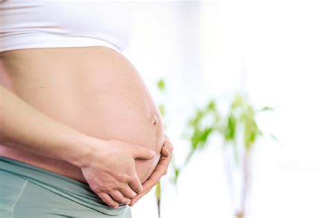 임신 마지막 달에 배를 부드럽게 잡고 있는 알아볼 수 없는 여성의 중간 부분의 측면 보기 임신 첫 삼 분기 18 주 측면도 흰색 배경입니다 36주 태아에 대한 스톡 사진 및