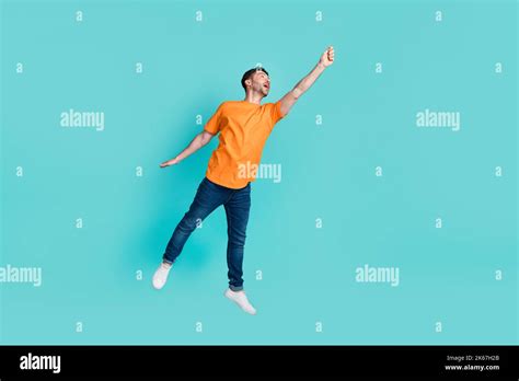 Full Body Photo Of Positive Person Raise Arm Hold Empty Space Banner Look Up Wear Orange Clothes