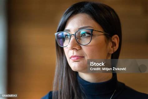 복사 공간 실제 사람과 함께 하루에 실내서 서있는 동안 검은 긴 머리와 안경을 가진 젊은 성인 백인 행복한 즐거운 여성의 전면 보기 초상화 20 29세에 대한 스톡 사진 및