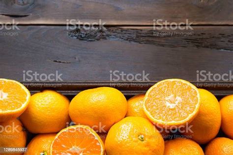 녹색 전나무 가지가있는 나무 배경에 갈색 상자에 신선한 귤 프레임 복사 공간 휴일과 겨울 향기 새해 크리스마스 건강한 음식 오렌지 주스 상점 창 슬라이스 및 절단 12월에