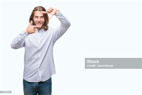 손으로 만드는 프레임 및 행복 한 얼굴로 손가락을 웃 고 고립 된 배경 위에 긴 머리를 가진 젊은 잘생긴 남자 창의력과 사진