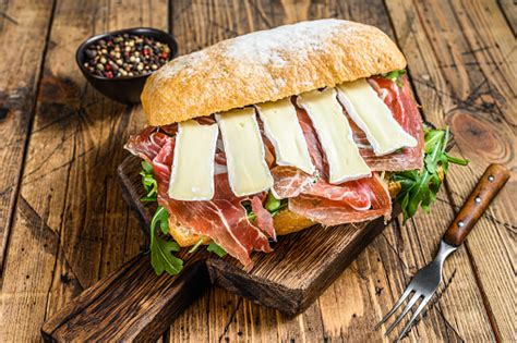 아루굴라와 카망베르 브리 치즈를 곁들인 시아바타 빵에 있는 파르마 햄 샌드위치 나무 배경 위쪽 보기 샌드위치 음식에 대한 스톡 사진 및 기타 이미지 Istock