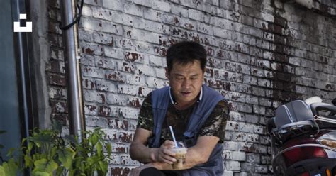 파란색과 검은색 티셔츠를 입은 남자가 빨간 플라스틱 의자에 앉아 있습니다 사진 Unsplash의 무료 서울 이미지