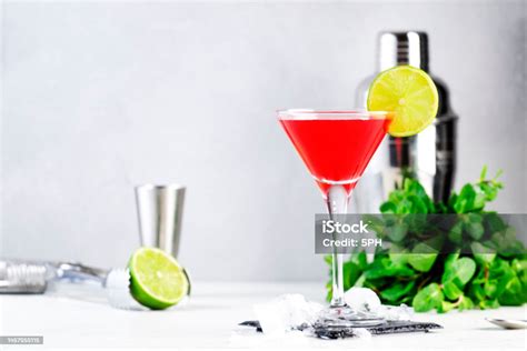 보드카 리큐어 크랜베리 주스 라임 얼음을 곁들인 코스모 폴리탄 클래식 알코올 칵테일 회색 테이블 배경 막대 도구 복사 공간 0