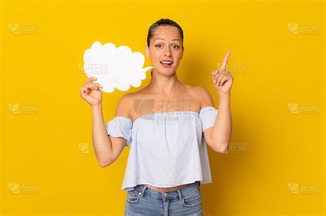 美丽微笑的年轻女子的肖像手捧空白纸演讲稿云举起手指思考着新的想法孤立在黄色背景上