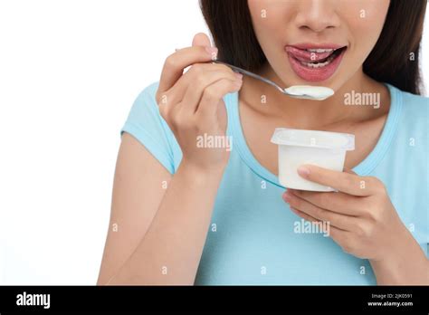 Close Up Shot Of Unrecognizable Dark Haired Woman Licking Her Lips While Holding Yogurt Cup And