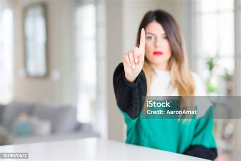손가락을와 화 식 집 패 니 얼에 겨울 스웨터를 입고 젊은 아름 다운 여자 가리키기에 대한 스톡 사진 및 기타 이미지 가리키기 가정 생활 갈색 머리 Istock