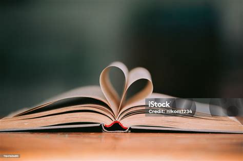 오래된 책 페이지는 흐릿한 배경과 빈티지 톤 스타일로 발렌타인 데이에 사랑에 대한 하트 모양으로 장식합니다 열린 책의 마음으로 사랑의 구성 책의 사랑 도서관 교육 텍스트의