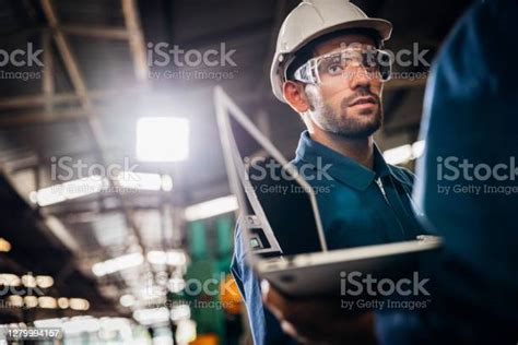 노트북 컴퓨터 산업 엔지니어 건설 개념에 의해 공장 스테이션에서 검사 및 검사 하에 균일하고 안전 헬멧을 착용한 산업 유지 보수 엔지니어 제복에 대한 스톡 사진 및 기타
