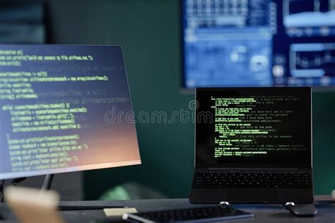Laptop With Code On Screen Standing On Programmers Desk With Computers