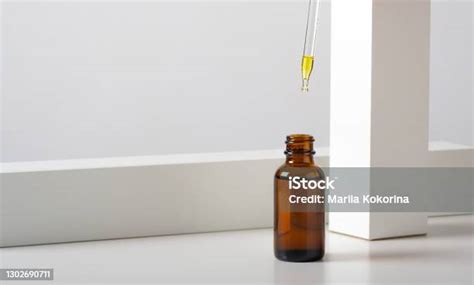 모의 화장품 얼굴 세럼 기하학적 장식이있는 세련된 미니멀 한 흰색 배경에 파이펫이있는 오일 브라운 유리 병 여성 뷰티 컨셉 빈 템플릿 공간을 복사합니다 0명에 대한 스톡