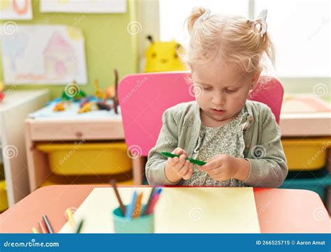 Adorable Blonde Girl Preschool Student Sitting On Table Drawing On