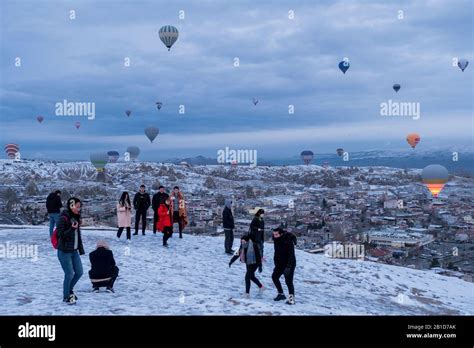 Cappadocia In Winter Covered With Snow Tourists And Hot Air Balloon