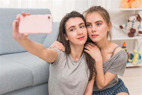 Retrato de par jovem lésbica levando selfie ligado smartphone casa Foto Grátis