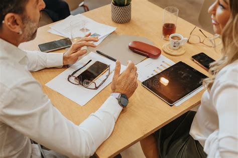 Middle Aged Male Business Person Explaining Something To His Blonde