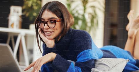 파란색과 검은색 스웨터를 입은 매력적인 백인 갈색 머리가 침대에 뱃속에 누워 노트북에 타이핑하고 있다 사진 Unsplash의 세르비아 이미지