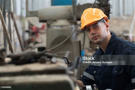산업 공장의 작업 유지 보수 기계에서 일하는 남성 공장 노동자는 안전 유니폼 안경 및 안전모를 착용하고 있습니다 작업장에 있는 백인 남성 기술공 그리고 무거운 강철 선반