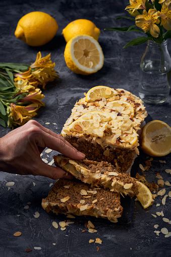 양귀비 씨앗과 코코넛 설탕을 곁들인 비건 홈메이드 레몬 케이크 레몬 슬라이스와 아몬드와 흰색 유약 선택적 초점 어두운 사진 스타일 0명에 대한 스톡 사진 및 기타 이미지
