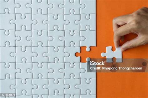 여자 손에 직소 퍼즐의 조각 직소 퍼즐 흰색 색상 퍼즐 조각 그리드 성공 모자이크 솔루션 템플릿 텍스트에 대한 오렌지 배경 복사 공간에 수평 상단보기 0명에 대한 스톡 사진