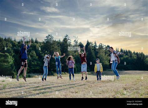 Students And Teachers Jumping On Meadow During Biology Field Teaching Students And Teachers Jumping On Meadow During Biology Field Teaching