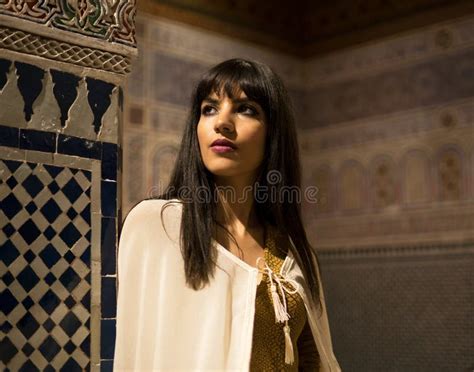 Beautiful Moroccan Girl In Short Golden Dress And White Mantle Cloak In Rich Interior Of