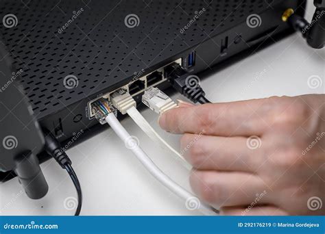 A Close Up Of A Person Plugging Wires Into A Router A Person Connects To A Wireless Router
