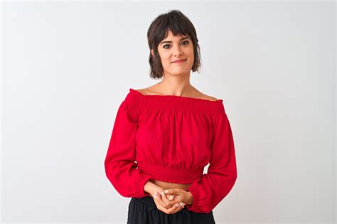 빨간 여름 티셔츠를 입은 젊은 아름다운 여성은 손을 함께 고립 된 흰색 배경 위에 서서 편안하고 쾌활한 미소를 지으며 손가락을